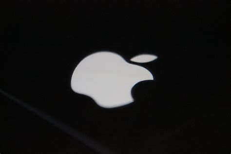 Illuminated Apple Logo On Black Smartphone Surface Pickpik