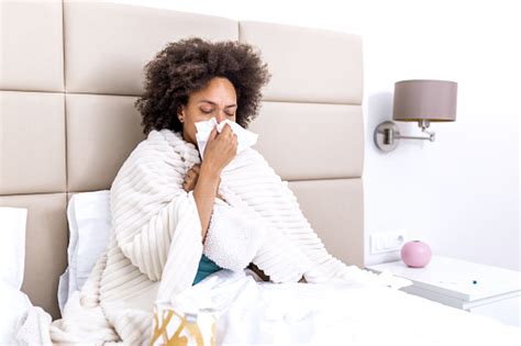 아픈 젊은 아프리카 여자 는 담요로 덮여 차가운 느낌 침대에 앉아 아픈 흑인 소녀 떨고 집에서 냉동 온난화 격자 무늬 아니 중앙 난방 문제 발열 온도 독감 개념 30 34