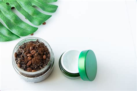 유리 항아리에 지상 커피와 설탕에서 바디 스크럽 흰색 배경에 몬스타와 얼굴 크림의 녹색 잎 홈메이드 필링 및 스파 케어 제품 0