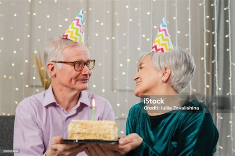 소원을 빌어보세요 파티 모자 모자를 쓴 가족 시니어 커플은 집에서 함께 생일 기념일을 축하합니다 2명에 대한 스톡 사진 및 기타 이미지 Istock