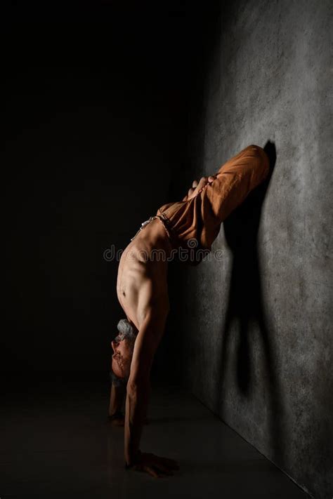 Aged Male With Naked Torso In Brown Pants Is Practicing Yoga Standing