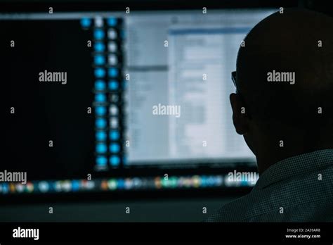 Developer Working Behind The Desk Analysing Diagram On The Monitor