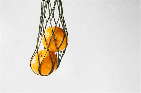 흰색 배경에 메쉬 문자열 가방에 신선한 귤 사물의 합리적인 재사용 사용 환경을 돌보는 습관 선택적 초점 가방에 대한 스톡 사진 및 기타 이미지 Istock