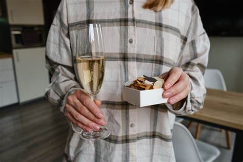 한 잔의 와인이나 샴페인을 소녀의 손에 들고 색종이 한 상자 알코올 음료의 맛 축하하고 순간을 즐길 수 있습니다 휴일을 위한 축제 장식 겨울에 대한 스톡 사진 및 기타