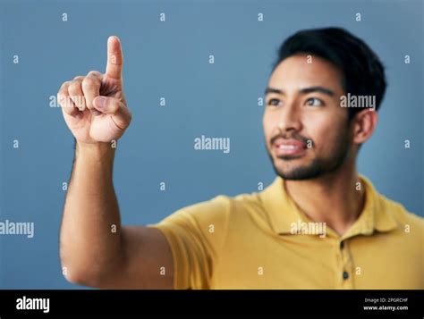 Finger Pointing And Asian Man With Invisible Hologram In Studio With Mockup Against Blue