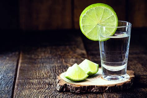 고품질 증류주 레몬 드립 보드카 화이트 럼 증류주 오조 사케 또는 브랜디와 함께 찍은 브라질 카차사 소박한 나무 배경에 음료 카챠카에 대한 스톡 사진 및 기타 이미지