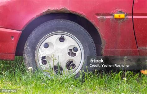 먼지와 얼룩이있는 풍화 된 자동차 바퀴 녹슨 버려진 차가 주차장에 있습니다 복고풍 자동차의 복원 플랫 타이어 클래식 레드 카