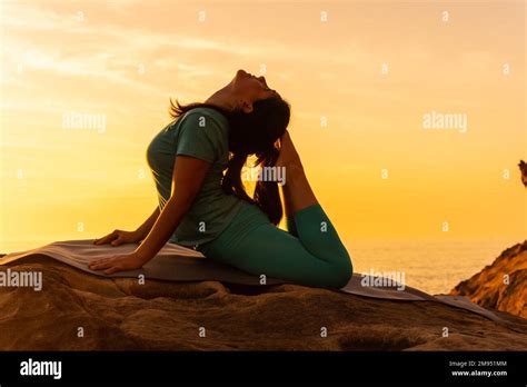 Bhujangasana A Woman Doing Meditation And Yoga Exercises At Sunset