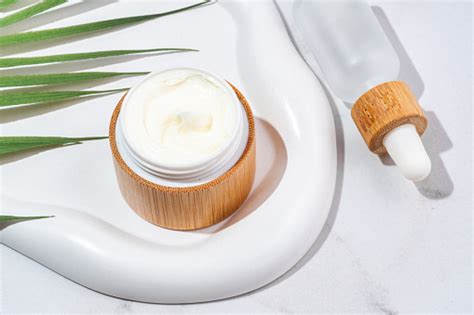 대리석 배경에 페이스 오일이 든 대나무 크림 항아리와 스포이드 병을 엽니다 화장품 용기 모형 브랜딩 및 포장 프레젠테이션을 위한 배경 자연 스킨 케어 미용 제품 개념입니다