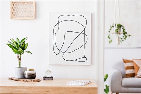 디자인 회색 소파 나무 책상과 커피 테이블 식물과 우아한 개인 액세서리와 아늑한 아파트에서 멋진 보헤미안 오픈 스페이스 인테리어