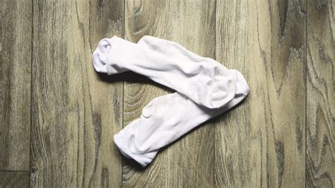 Man Takes Off His Wet Socks While Sitting On The Pier The Man Wears A