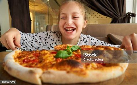 피자를 먹고 재미 도시 카페에서 소파에 앉아 있는 어린 소녀 건강에 좋지 않은 음식에 대한 스톡 사진 및 기타 이미지 건강에 좋지 않은 음식 귀여운 단일 객체