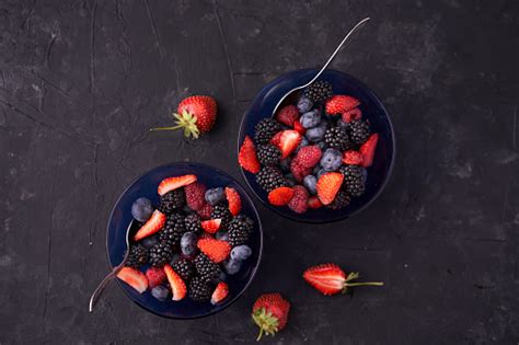 어두운 콘크리트 배경에 파란색 접시에 유기농 신선한 잘 익은 블랙 베리 딸기 라즈베리 블루 베리 건강한 식습관 채식 다이어트 위에서 보기 0명에 대한 스톡 사진 및 기타