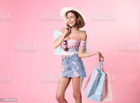 아시아 예쁜 젊은 여자 핑크 파스텔 배경을 통해 산책 그녀는 미소를 지으며 쇼핑백을 들고 있었다 그녀는 사랑스러운 매력적인 빛을