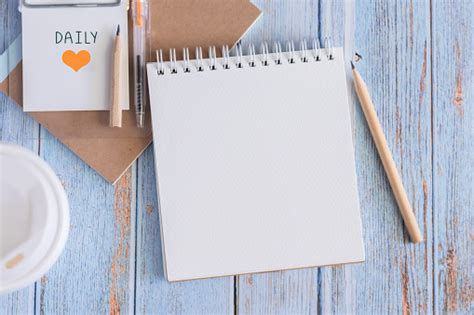 복사 공간이있는 파란색 파스텔 나무 배경에 연필과 커피 컵으로 텍스트와 메시지를 쓰기위한 상단보기 흰색 바인더 빈 노트북 이나 일기 또는 저널 여전히 라이프 스타일 사진