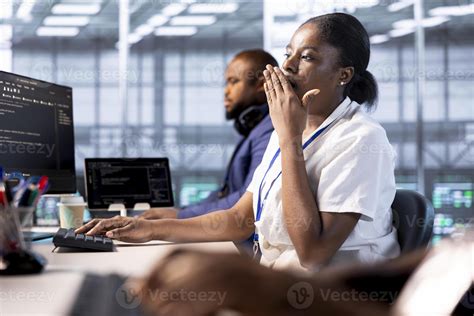bored data center technician yawning while creating technical documentation for software