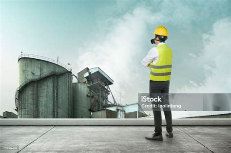 연기와 대기 오염을 바라보는 보호 마스크를 쓴 아시아 건설 엔지니어 남자의 뒷모습 엔지니어에 대한 스톡 사진 및 기타 이미지 엔지니어 건물 외관 건설 산업 Istock