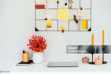 닫힌 노트북이 있는 홈 오피스 책상 가을 색상 팔레트 노트 모형 양초 꽃 호박과 같은 계절 장식이 있는 그리드 무드 보드 가을의 영감과 아늑한 분위기 Hygge 가정 가을