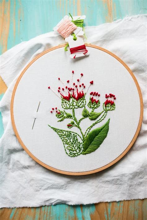 Hoop Modern Embroidery With Botanical Motifs On A Wooden Background