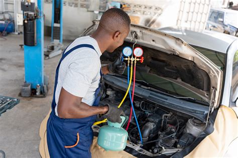 Ac 냉매 매니폴드 게이지 세트 정비사 작업장에서 자동차 에어컨 수리 엄지손가락을 치켜세우고 자동차 에어컨 시스템 냉매 충전을 확인하는 기술자 35 39세에 대한 스톡 사진