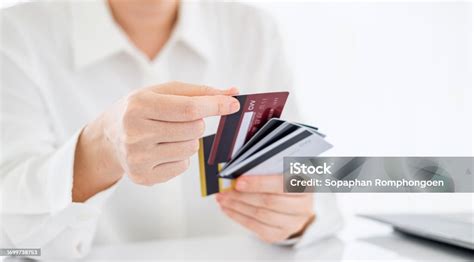 여자는 여러 개의 신용 카드를 들고 신용 카드를 통해 상품에 대한 지불을 지불하고 지출 할 신용 카드를 선택합니다 금융 및 은행 개념입니다 40 44세에 대한 스톡 사진 및