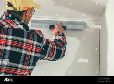 Professional Construction Worker Applying Plaster On Walls Using