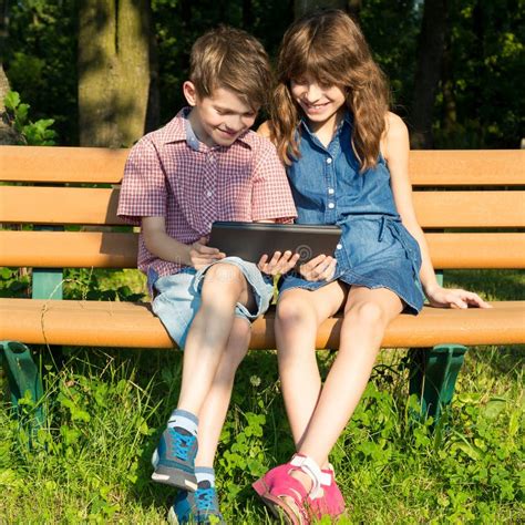 Junge Und Mädchen Sitzen Auf Einer Bank Im Park Und Betrachten