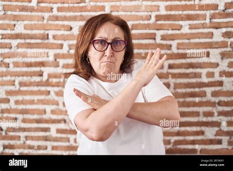 Senior Woman With Glasses Standing Over Bricks Wall Rejection