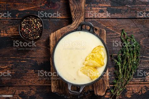 감자 크림 수프와 감자 칩을 냄비에 나무 판에 넣습니다 어두운 나무 배경 위쪽 보기 감자 요리에 대한 스톡 사진 및 기타 이미지 감자 요리 거품 내기 건강한 식생활