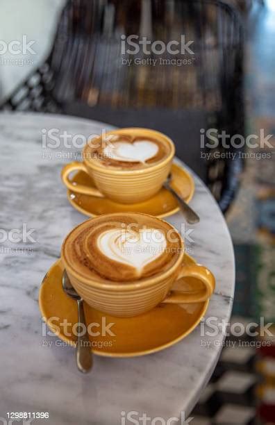 대리석 테이블 배경에 뜨거운 카푸치노의 두 개의 노란색 컵 사랑을 위한 아트 라떼로서의 하트 모양 카페에 대한 스톡 사진 및 기타 이미지 Istock