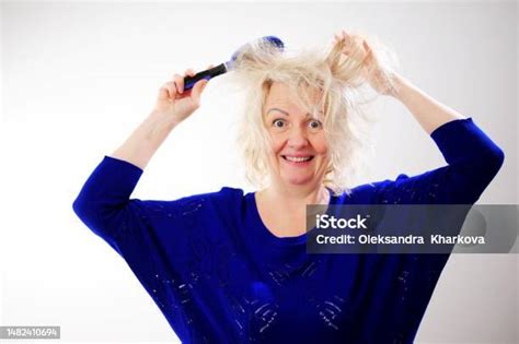 손상된 머리카락 흐트러진 빗을 가진 슬픈 성인 여성은 솔질되지 않은 마른 머리카락을 손에 들고 있는 여성 모델의 초상화를 근접 촬영합니다 모발 손상 건강 및 미용 개념