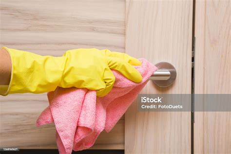 분홍색 고무 보호 장갑에 깨끗한 손은 마른 걸레와 나무 도어의 강철 핸들을 닦아 일반 또는 일반 정리 청소 서비스 근접 촬영 가사 집안일에 대한 스톡 사진 및 기타 이미지