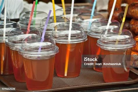 여러 가지 빛깔의 과일 음료 클로즈업 축제에서 플라스틱 컵에 무알코올 음료 주스와 채소를 곁들인 칵테일 하얀 연기가 칵테일로