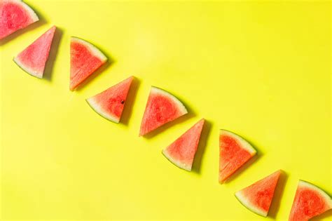 햇볕이 잘 드는 노란색 배경에 수박 조각으로 창조적 인 구성 다채로운 여름 개념 최소한의 신선한 과일 아이디어 0명에 대한 스톡