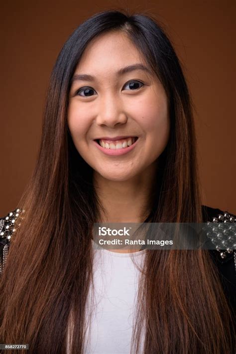 배경색에 대 한 멋진 자 켓을 입고 긴 스트레이트 머리를 가진 젊은 아름 다운 아시아 여자의 스튜디오 샷 20 24세에 대한 스톡 사진 및 기타 이미지 Istock
