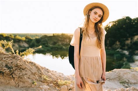 매력적인 금발 소녀 드레스와 밀 짚 모자 햇빛 연못 근처 배낭 포즈 가방에 대한 스톡 사진 및 기타 이미지 가방 금발 머리 드레스 Istock