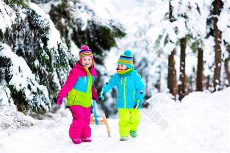 孩子们在雪地上雪橇在冬季公园玩耍图片 包图网企业站