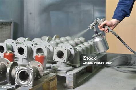 특별 한 방에서 공장에서 노동자는 스프레이 건에서 밸브의 부분을 페인트 회색 색깔 손 및 살포 총 가까이에 있는 페인트 벨 브 개선에 대한 스톡 사진 및 기타 이미지