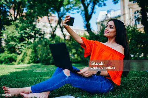 매력적인 젊은 여 자가 포즈를 하면서 휴대 전화 Selfie 방학 동안 대학 학생 매력적인 소셜 네트워크에서 스마트폰 카메라 블로깅에 복용 그림 숙제를 하 고 있는 동안