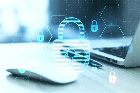 Close Up Of Laptop Computer Mouse And Pen At Desk With Glowing Hexagonal Padlock Hologram And