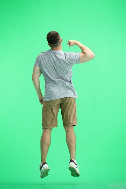 premium photo a man in a gray tshirt on a green background fulllength