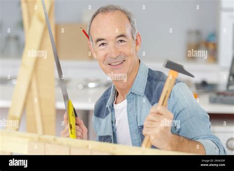 Senior Man Working With Wood And Holding Tools Stock Photo Alamy