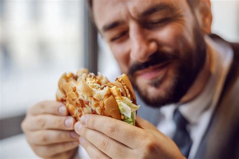 젊은 잘 생긴 수염 사업가 패스트 푸드 레스토랑에 앉아 햄버거를 먹고 먹기에 대한 스톡 사진 및 기타 이미지 먹기 건강에 좋지 않은 음식 건강하지 못한 생활방식