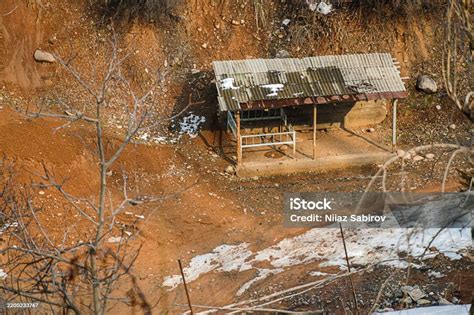산의 경사면은 철염을 함유 한 붉은 점토로 만들어졌으며 그 위에 슬레이트 지붕이있는 열린 캐노피가 세워지고 바닥에는 콘크리트가 부어졌습니다 도로는 자동차 자국과 녹은 빽빽한