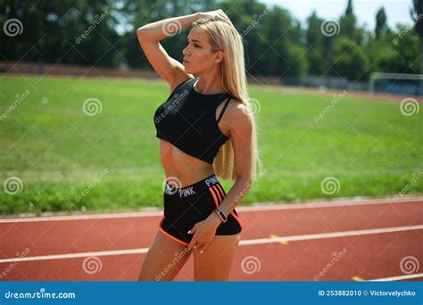 A Beautiful Slender Blonde Girl Athlete Coach Is Engaged On The Street On The Playground Doing