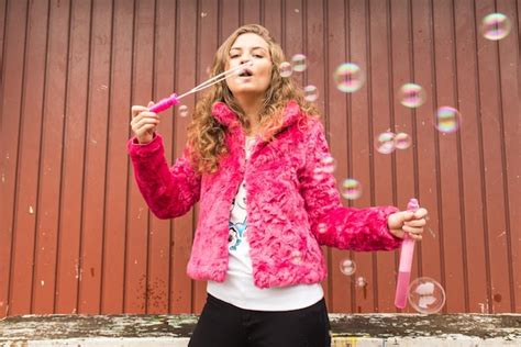 Portrait Of Woman Blowing Bubbles Premium Photo