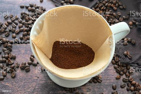 종이 필터 백과 도자기 홀더에 커피를 넣고 향기로운 드립 양조 뜨거운 음료 콩이 있는 소박한 나무 테이블을 위한 분쇄 커피