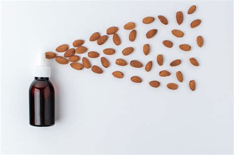 흰색 배경에 투명 화장품 호박색 유리 스프레이 병 아몬드는 스프레이에서 작은 물방울처럼 흩어져 있습니다 평평한 평신도 0명에 대한 스톡 사진 및 기타 이미지 Istock