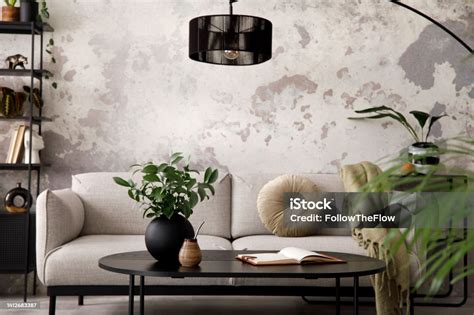 디자인 회색 소파 검은 커피 테이블 램프 및 우아한 개인 액세서리가있는 현대적인 아파트의 로프트 스타일 로프트 및 산업 인테리어