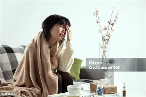 격자 무늬에 싸여 여자는 아픈 보인다 아픈 재채기와 실내집에서 앉아 기침 20 24세에 대한 스톡 사진 및 기타 이미지 20 24세 가정 생활 감기와 독감 Istock